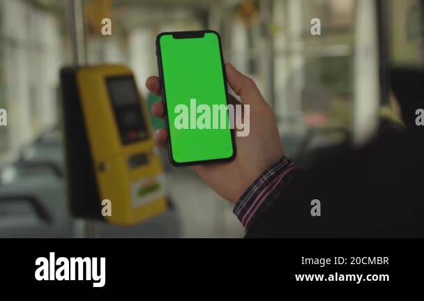 NEW YORK - May 19, 2019: Close up hand man uses holding a mobile phone with a vertical green ...