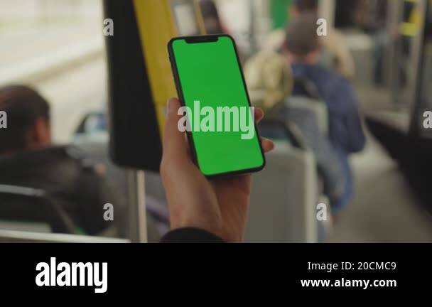 NEW YORK - May 19, 2019: Hands man young uses holding a mobile telephone with a vertical green ...
