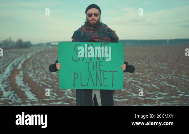 Young man activist with Save the Planet ecology poster in field ...