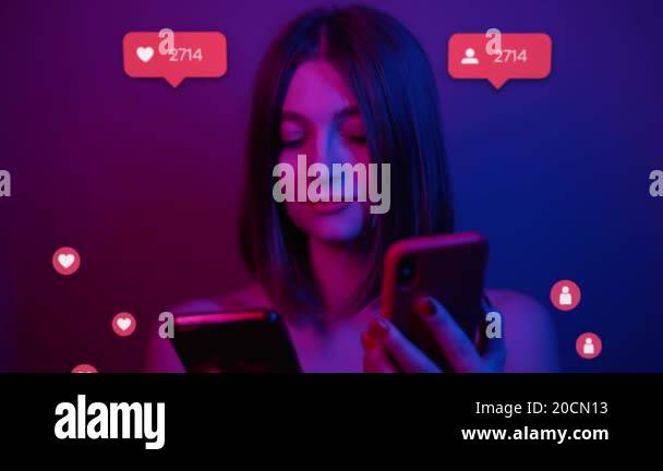 Close up woman on colorful light use phone typing social media icons ...