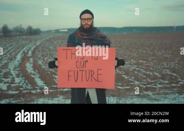 Serious man activist with ecology poster This is our Future in field ...