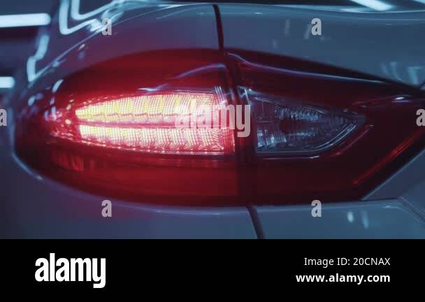 Car detail. Modern new white car tail lights shining red close-up. Rear ...