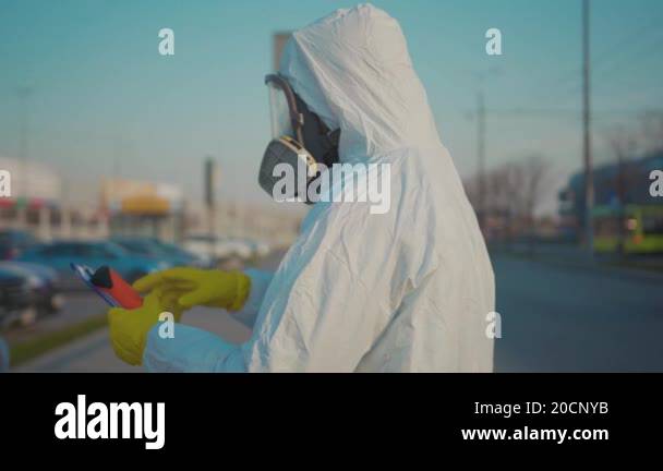 Shot of medical worker in protective suit screening passenger to check ...