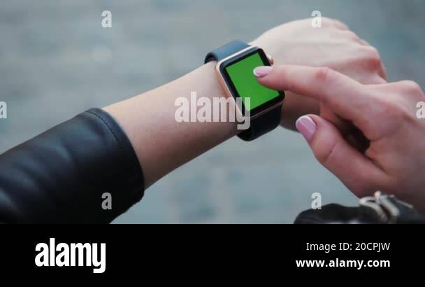 NEW YORK - April 5, 2018:Close up woman hands use smartwatch with green ...
