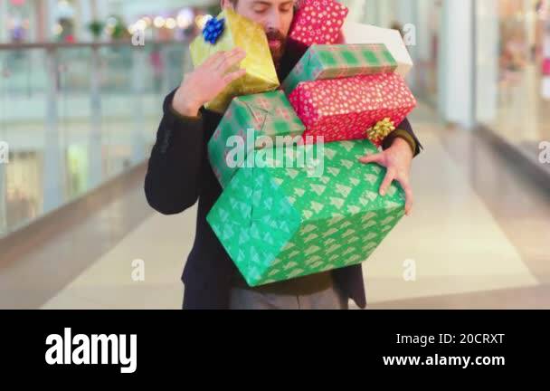 Tired sad attractive man trying to keep the boxes constantly falling to ...