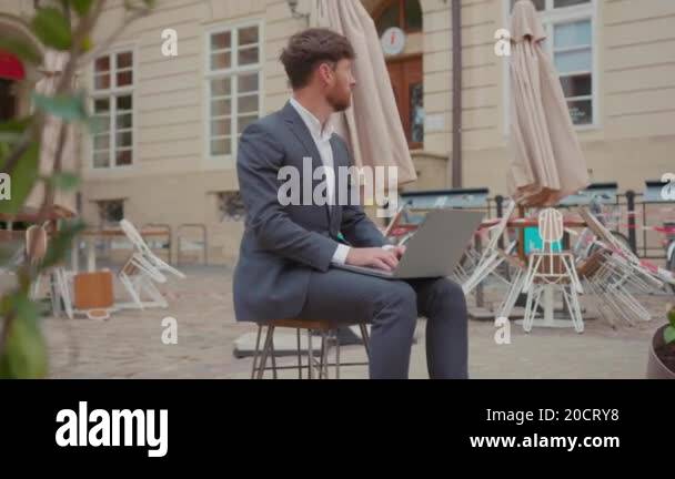 Frustrated unemployed caucasian business owner in suit sits with laptop ...