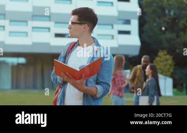 Young caucasian man intelligent student reading a book learning ...