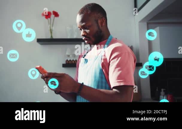 Excited afro-american man staying in kitchen using smartp-hone ...