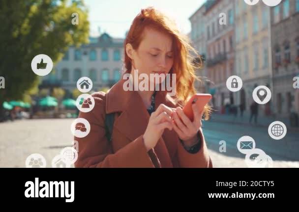 Displeased ginger popular young woman using smartphone getting tired of ...