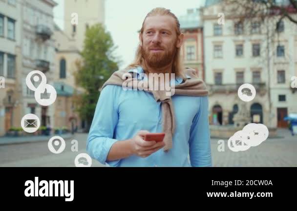 Young bearded man use phone walking on city street . Successful elegant ...
