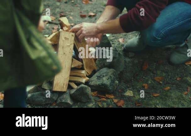 Hands father and daughter in the woods sets up campfire sticks. Talking ...