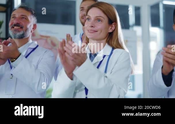Multi-race professional medical staff with female boss applauding ...