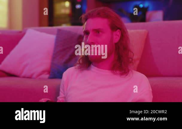 Scared young caucasian man watching TV horror scene movie looking ...