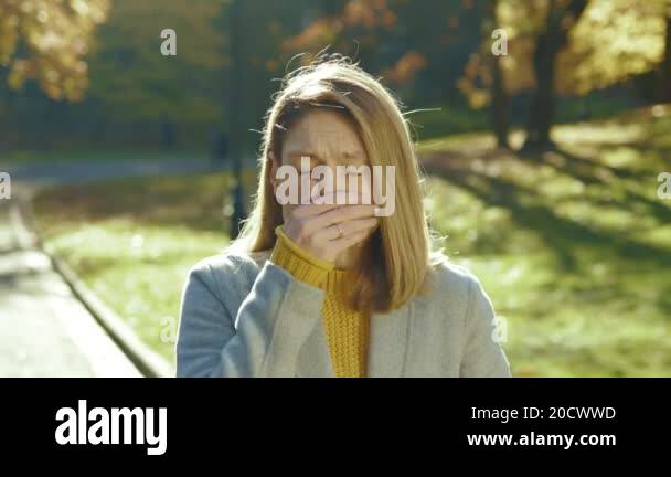 Portrait young woman stand look at camera feel cold sneezes in autumn ...