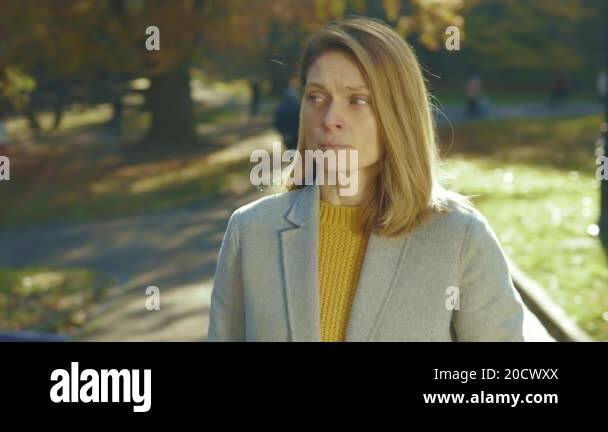 Upset young woman stand look at camera tired sad sick in autumn park at ...