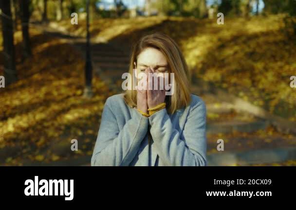 At sunlight face sick young woman having headache feel cold sneezes ...