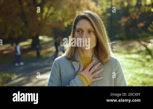 Face sad sick young woman stand look at camera feel cold in autumn park ...