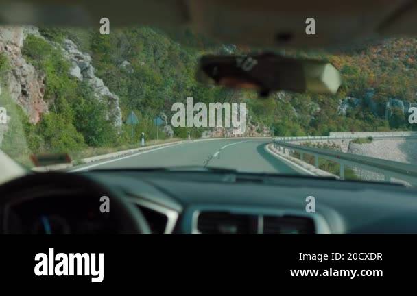 Drivers seat. Car driving through mountainous terrain, green valley. No ...