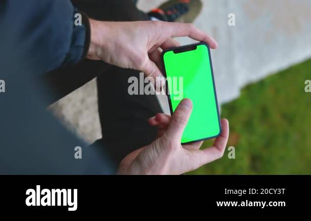 Vertical shot over the shoulder of man hands use phone with horizontal ...