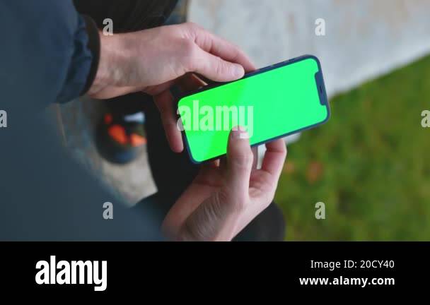 Outdoors vertical shot over the shoulder of man hands use phone with ...