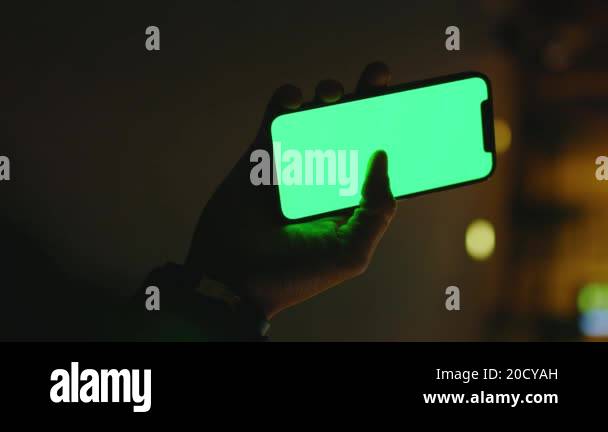 Vertical shot hands man use phone with vertical green screen stand at ...