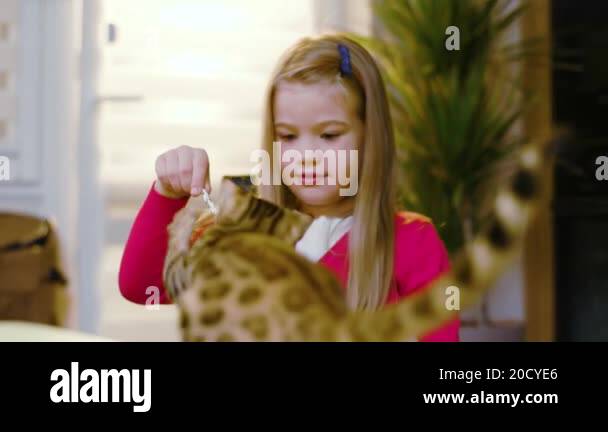 Child girl learning writing doing homework sitting at home table. Cat ...