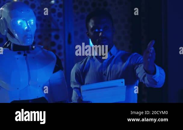 African american businessman work talking with cybernetic robot use ...