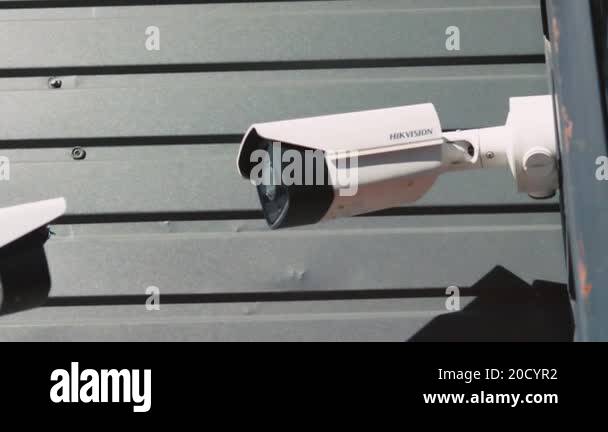 Two security camera moving recording outside a building at sunlight ...