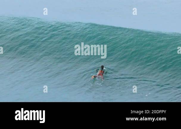 This aerial photograph captures surfers riding majestic waves ...