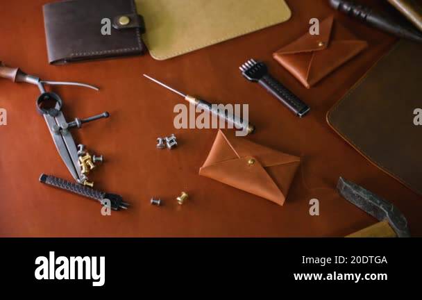 A collection of leatherworking tools and completed handmade wallets ...