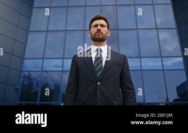 Determined executive crossing hands posing at contemporary building ...