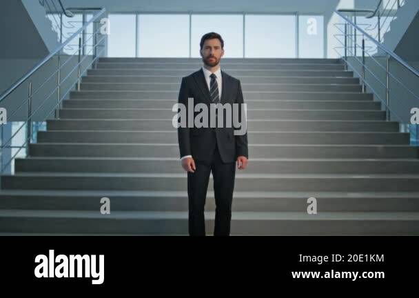 Friendly director posing at office staircase pointing finger to camera ...