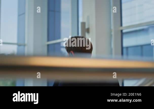 Busy entrepreneur talking mobile phone walking down staircase modern ...