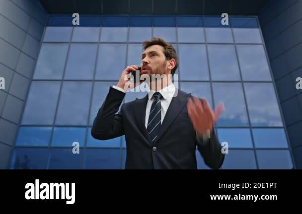 Mad ceo yelling in mobile phone emotionally gesturing outside glass ...