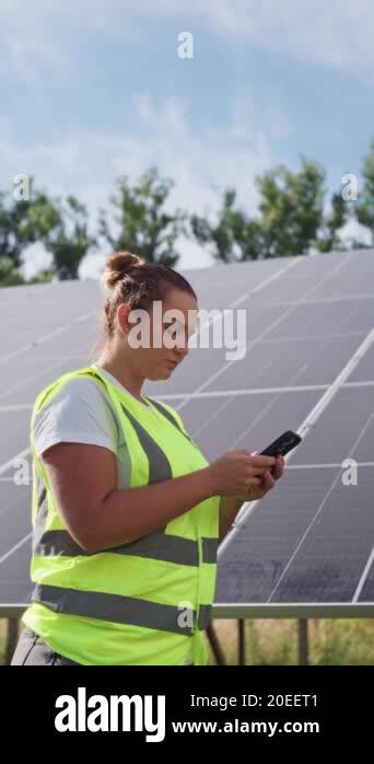 Female Engineer Configuring Solar Panels with Smartphone Highlighting ...