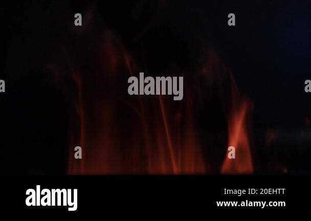 Orange, red smoke in the light of different colors on a black ...