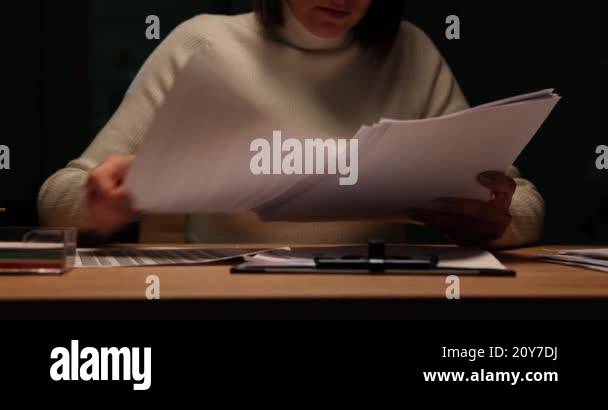 Organizing important documents on a table at night in the office ...