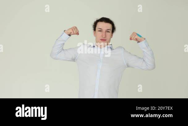 Young man confidently flexes muscles demonstrating strength and fitness ...