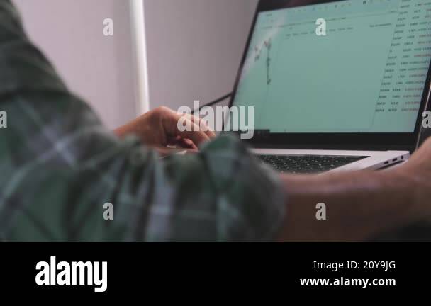 A person is sitting in front of a laptop, looking at a graph on the ...