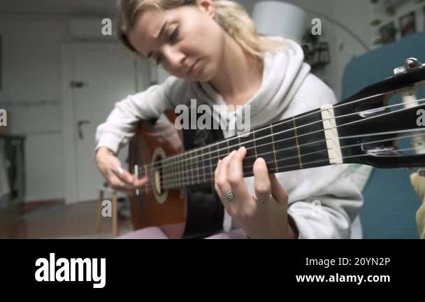 Musician concentrating on a melody while playing a six-string acoustic ...