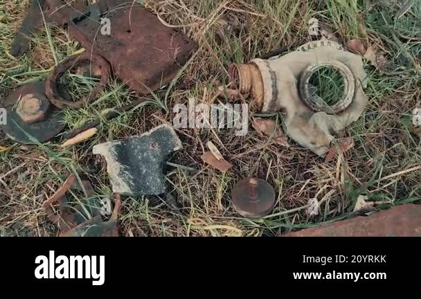 A broken gas mask and various metal rusty parts lie on the grass. Post ...