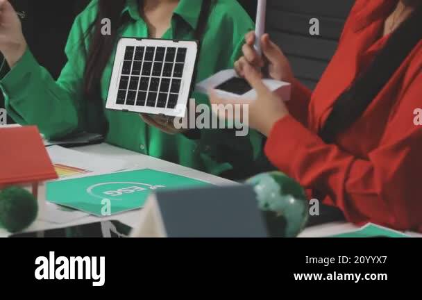 young businesswoman in green suit and suit holding a green solar energy ...