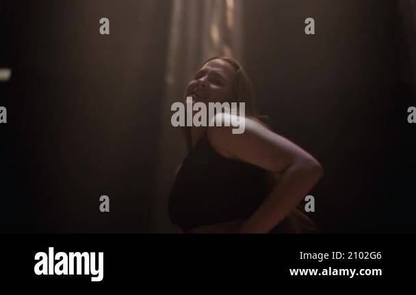 A girl showcasing an expressive dance routine under bright beams of ...