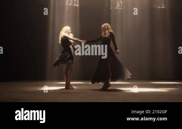 A young dance duo performs fluidly under bright studio lights ...