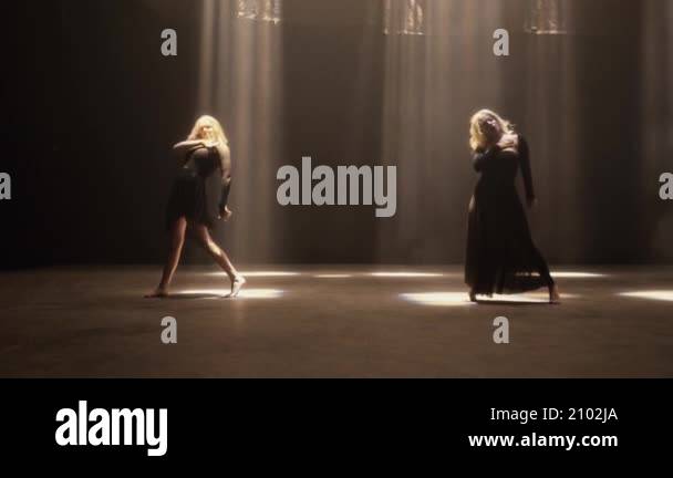 Two young performers dance together under vibrant studio spotlights ...