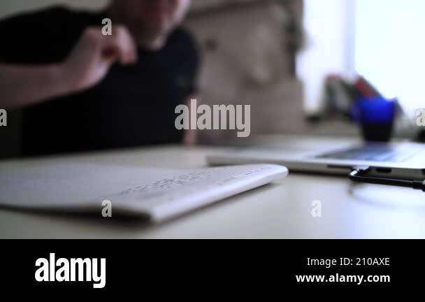 man journaling his thoughts into notebook, because he has some sort of ...