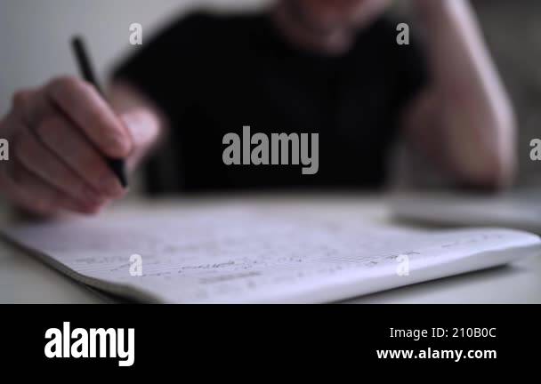 man journaling his thoughts into notebook, because he has some sort of ...