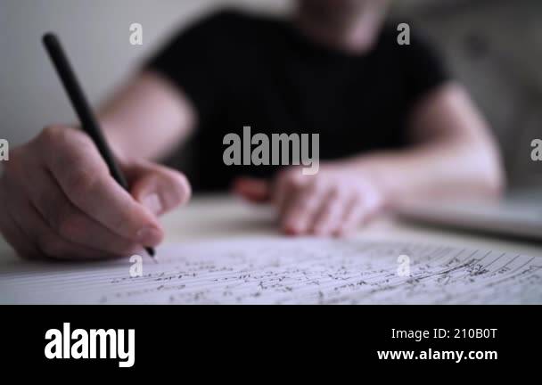 man journaling his thoughts into notebook, because he has some sort of ...