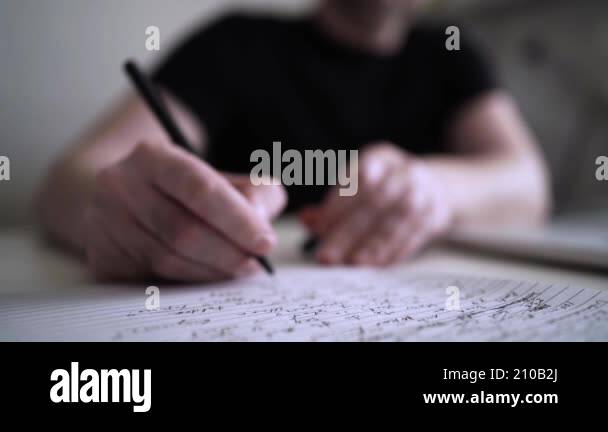 man journaling his thoughts into notebook, because he has some sort of ...