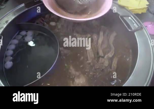 delicious beef stew with entrails and meatballs are decorated by green ...